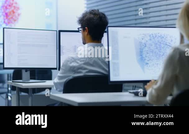 Team of Talented Computer Engineers Programming at Their Workstations ...