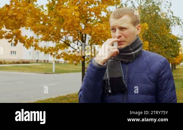 male with cold in the head, ill male wearing warm scarf is on the ...