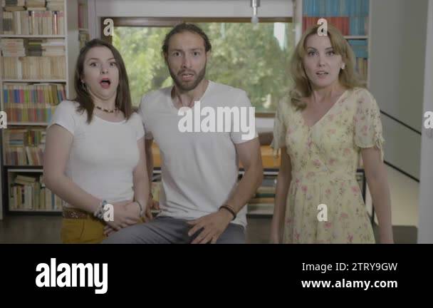 Group of millennial friends gathered at home having scared reaction ...