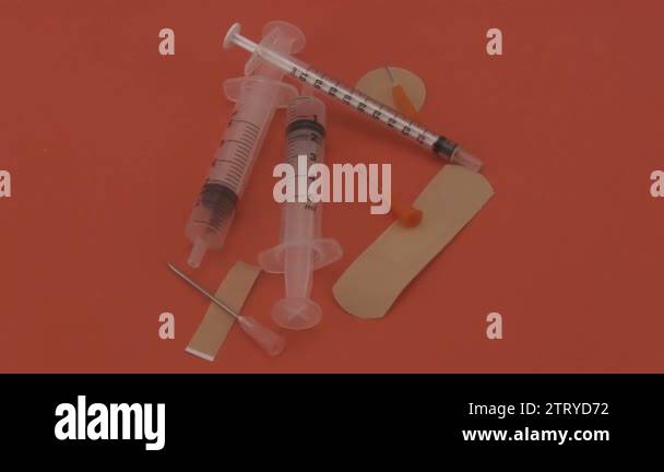 Hypodermic syringe and needle rotating on a red background Stock Video ...