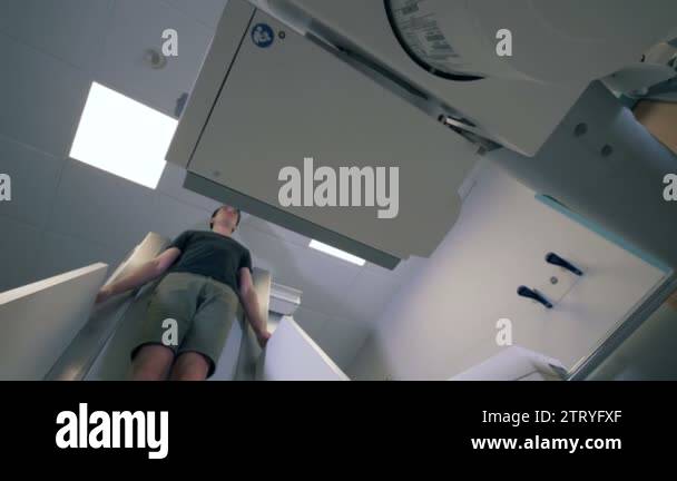 Medical scanning machine is moving upwards during procedure held on a ...