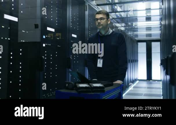 IT Technician in Data Center Pushes Crash Cart Through Sliding Doors ...