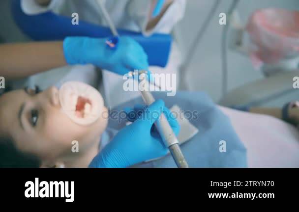 Dentist takes dental instrument and turns to patient. Doctor with nurse ...