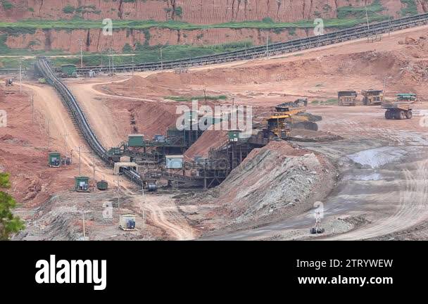 heavy construction tipper trucks dump coal to the conveyor at coal mine ...