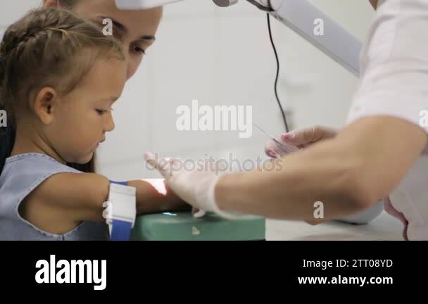 Little girl with mother in hospital. Nurse taking girls venous blood ...