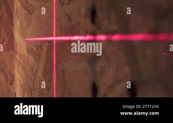Construction laser level and red lines of a marking on a wall surface ...