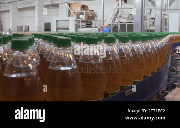 The production line of lemonade. A conveyor of plastic bottles filled ...