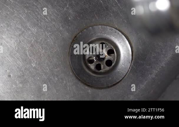 Water drops dripping from a tap into a kitchen sink, cinematic ...