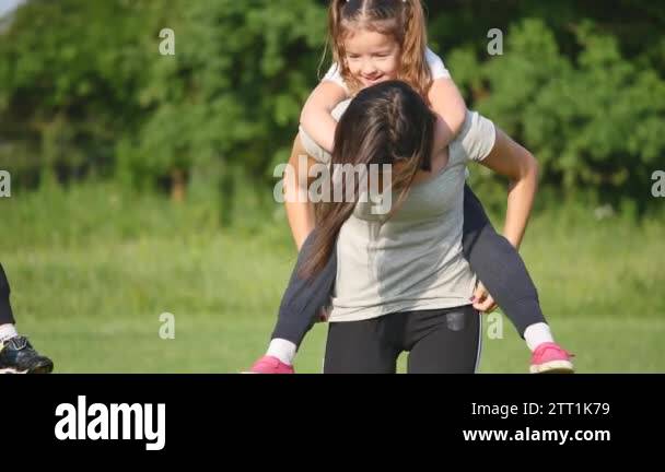 Beautiful family doing physical jerks outdoor. Family tilts and do ...