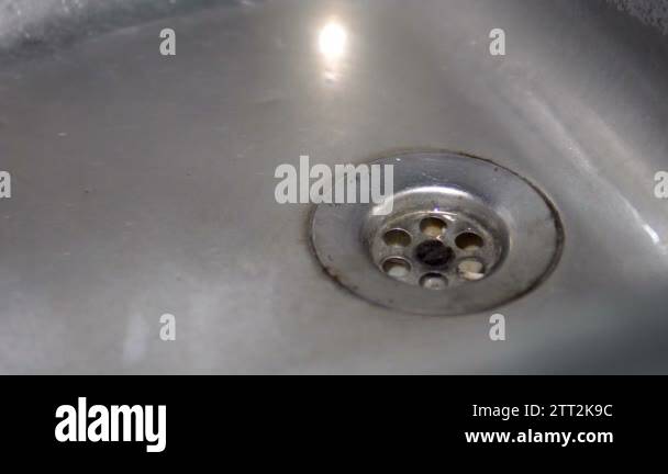 Water drop dripping down the drain, deep sinkhole, background loop ...