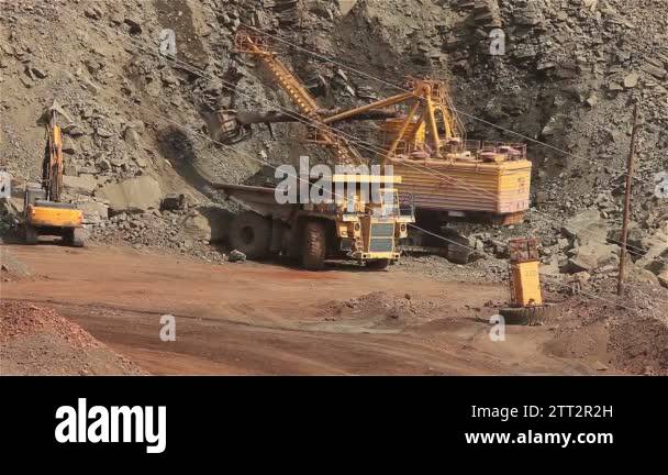 Excavator and dumper in the quarry, excavator loads the raw materials ...