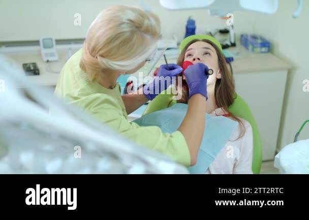 Teeth treatment process with dental curing light. Dentist working with ...