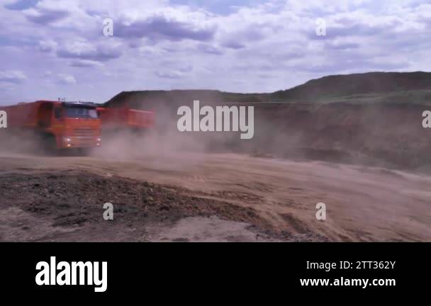 Dump truck on dirt road in large dust cloud. Scene. Fog of dust on ...