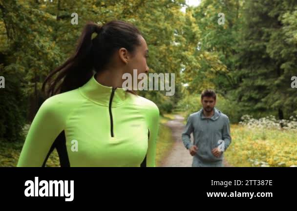 Woman runner looks back to his partner while running and winning race ...