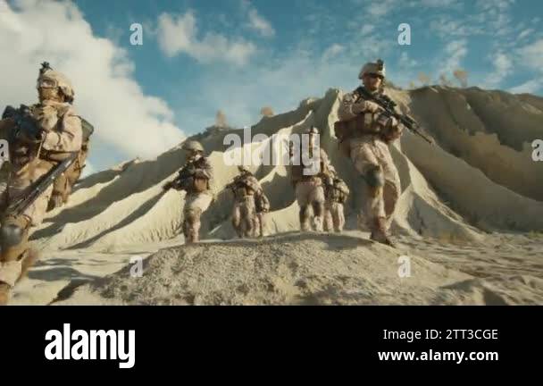 Squad of Fully Equipped and Armed Soldiers Walking down the Hill in the ...