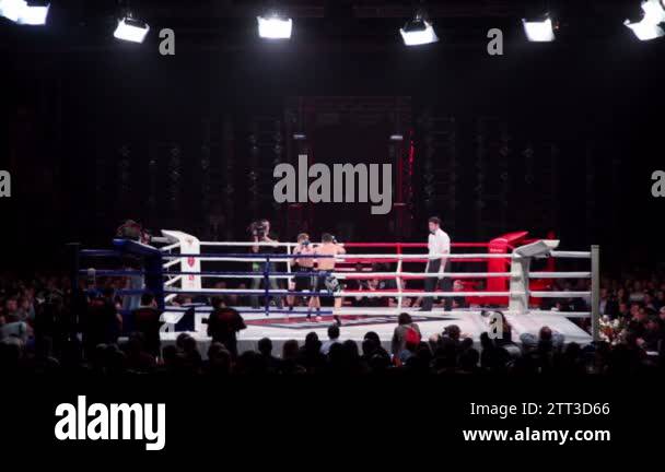 Two athlete fight on boxing ring in large dark hall at The Battle of ...