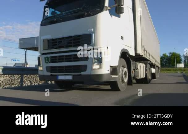 White Semi Truck with Cargo Trailer Drives Out of Industrial Loading ...