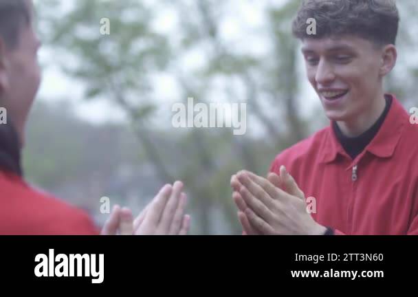 Two men are playing kids game clapping each other hands outdoors ...