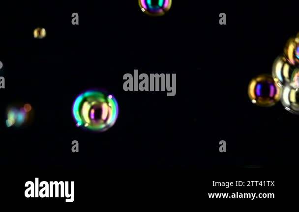 Different size and color soap bubbles fly close up. Slow motion. Black backgrounds Stock Video ...