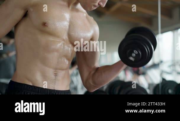A shirtless guy at the gym, trains his body to stay fit and have ...