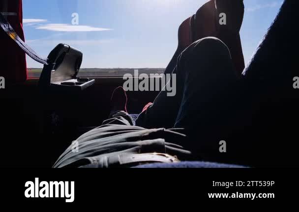 Male tourist lying travelling by bus, low cost transport, student trip ...