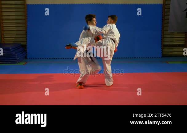 Two boys fighting in a combat and one puts down the other with martial ...