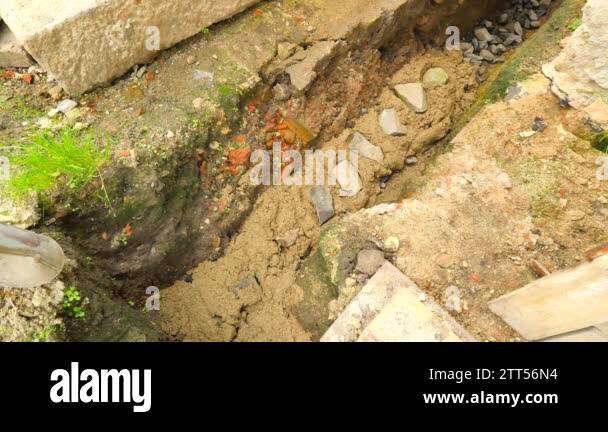 Pouring, laying concrete into foundations of the house using shovel of ...