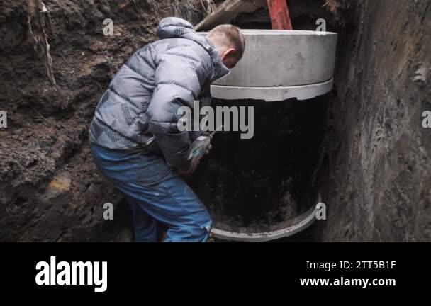 Man drilling hole in concrete chamber manhole ring in ditch Stock Video ...