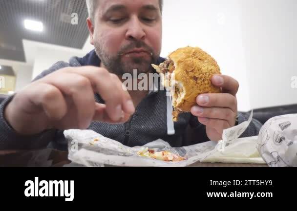 Hungry man eating big hamburger in fast food cafe Stock Video Footage ...