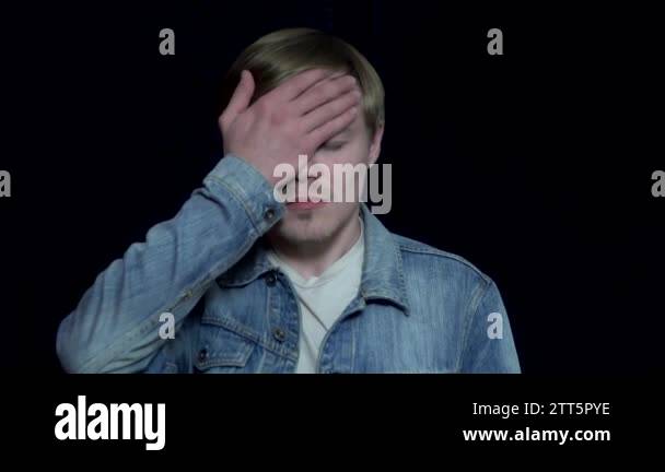 Man closes face with hand in frustration. Young man is disappointed and ...