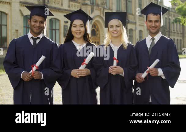 International students in graduation outfit holding diplomas, quality ...