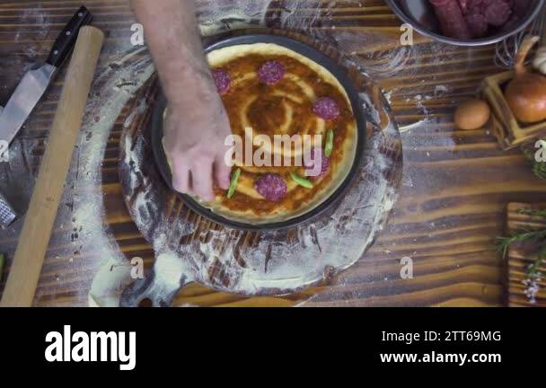Pizzaillo cooking pizza with sausage pepperoni on wooden table top view ...