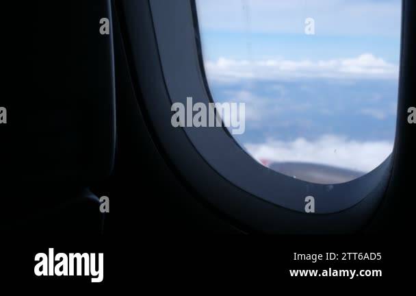 Clouds and sky as seen through window of an aircraft flying, plane ...