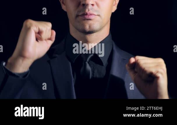 super close-up of a man in black clothes on a black background. 4k ...