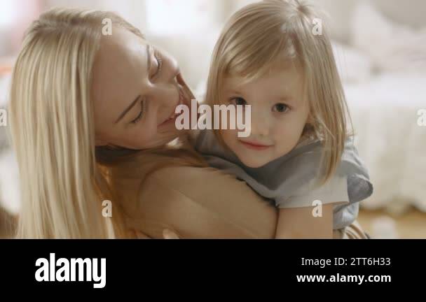 Young Beautiful Mother Holds Her Little Cute Daughter In Her Arms. They ... Young Beautiful Mother Holds Her Little Cute Daughter In Her Arms. They ...