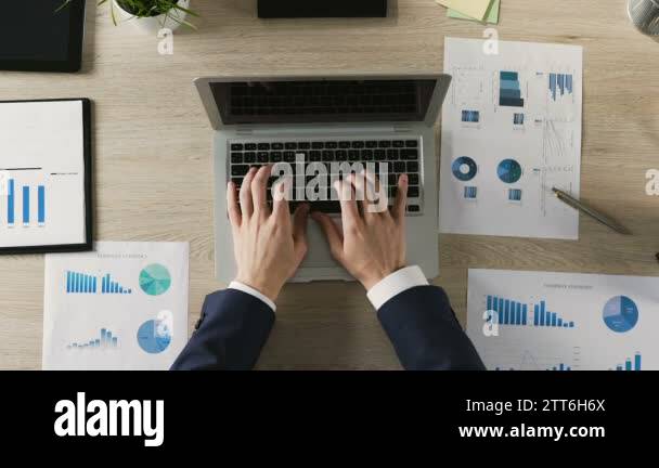 Man finishes typing and closing laptop, leaving office at end of ...