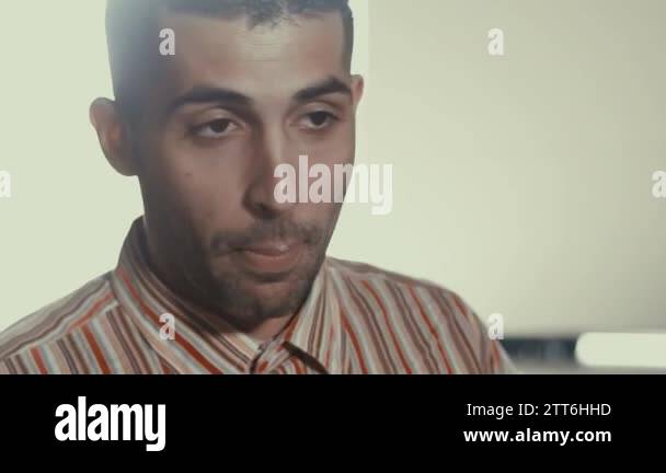 Colombian gangster in a white shirt in the style of the 80s stands near ...