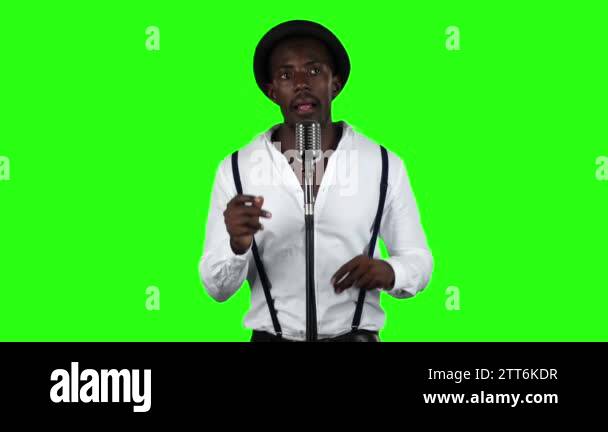 Man vocalist sings into a microphone and dance. Green screen. Slow ...