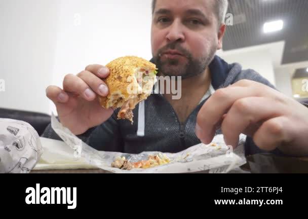 Hungry man eating big hamburger in fast food cafe Stock Video Footage ...