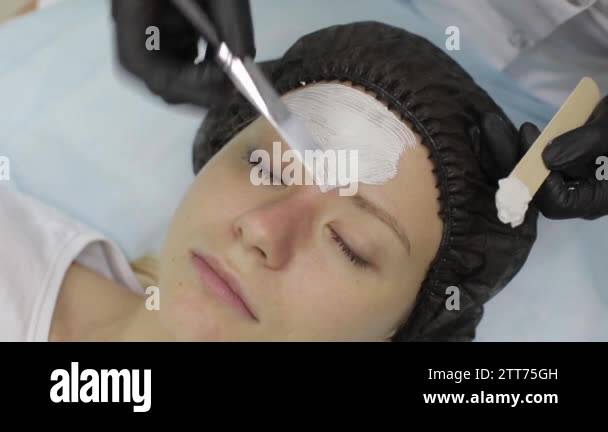 Close up of a face of beauty salon visitor, black mask is applied on ...