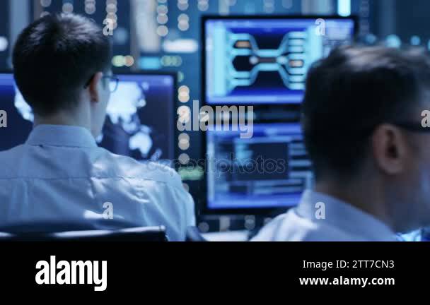 In the Monitoring Room Team of System Engineers Working at Their Workstations. Multiple Displays ...