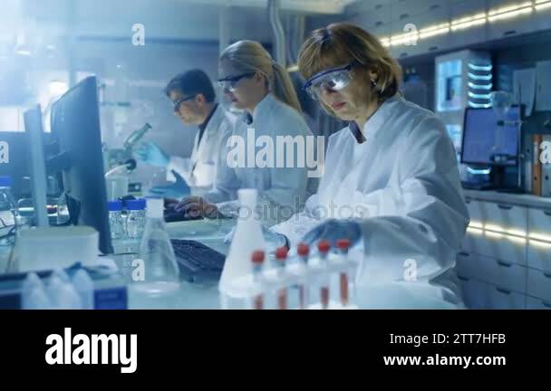 Female and Male Scientists Working on their Computers In Big Modern ...