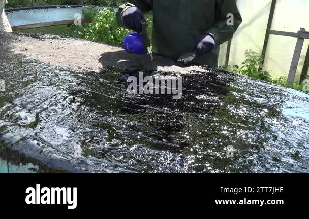 Builder man hands repair lay tar on roof surface with special tools. 4K ...