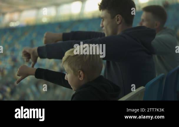 Student fans and little boy booing sport game at stadium, watching ...