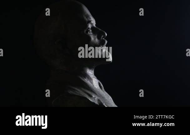 Spinning portrait sculpture of Vladimir Lenin on black background. Era ...