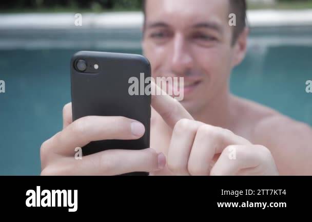 Attractive and handsome young man looks, scrolls through social media ...