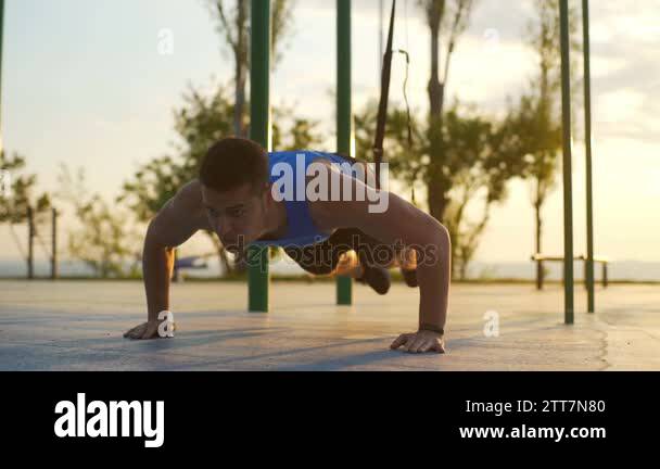 strong man engaged in trx exercise push ups pulling the body workout ...