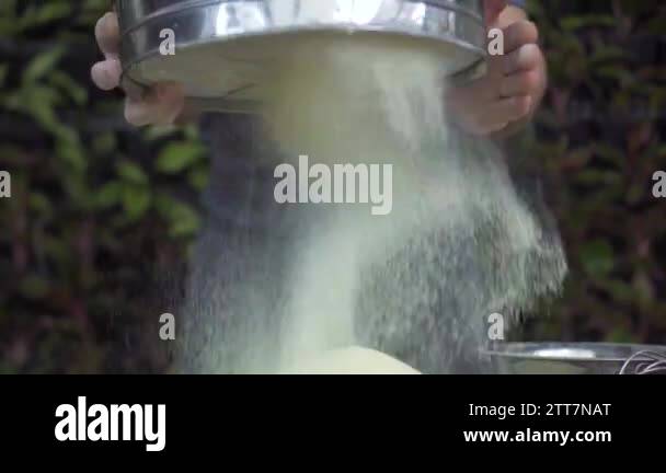 Baker poring flour powder through sieve for baking slow motion. Chef ...