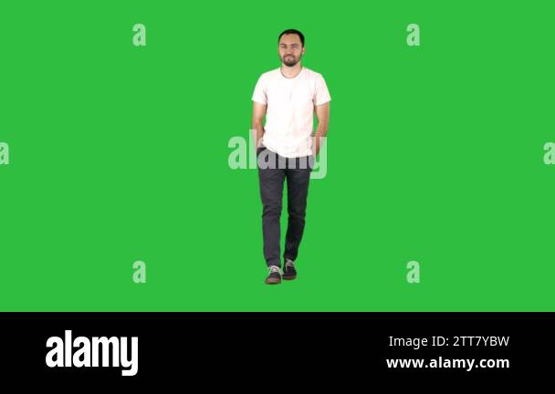 Confident young adult man walking forwards and looking at camera in ... Confident young adult man walking forwards and looking at camera in ...