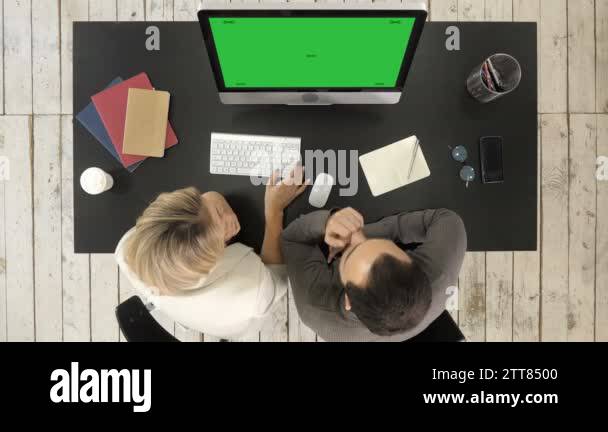 Business couple talking and watching image on screen of monitor. Green ...